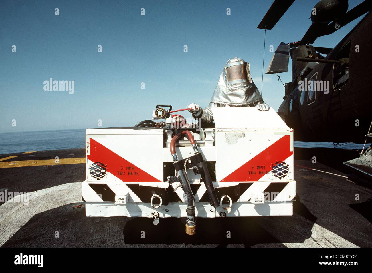 A crash crewman wearing a fire fighting suit stands by in a damage ...