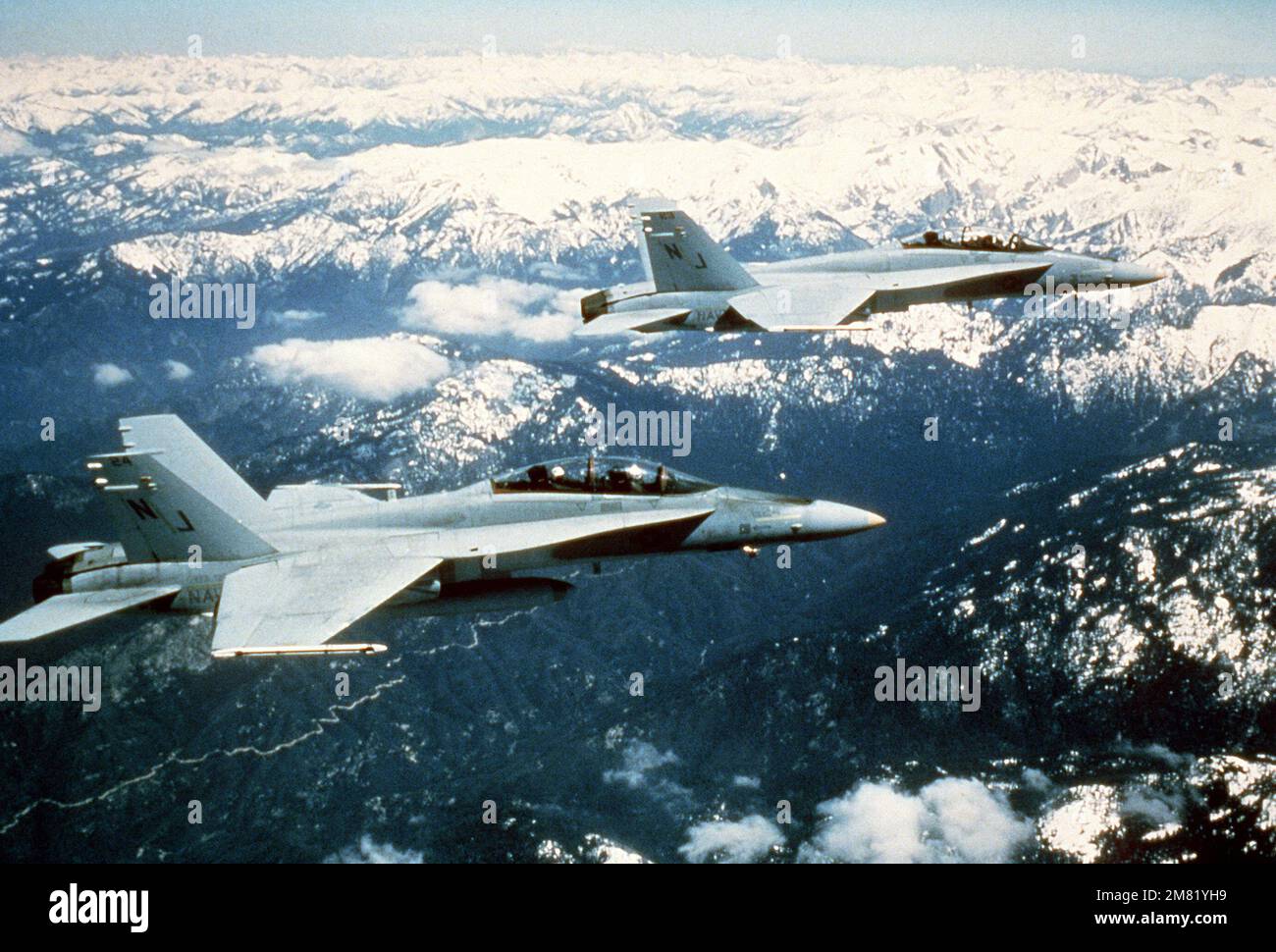 An air-to-air right side view of two TF/A-18 Hornet aircraft from ...