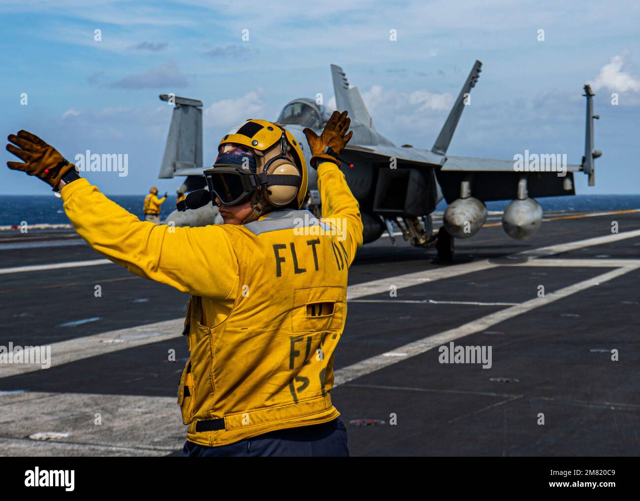 230110-N-MH015-1002 PHILIPPINE SEA (Jan. 10, 2023) A U.S. Navy Sailor directs an F/A-18E Super ...