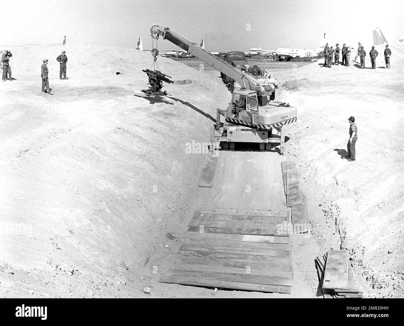 A crane is used to move a specially-designed cannon into a firing pit ...