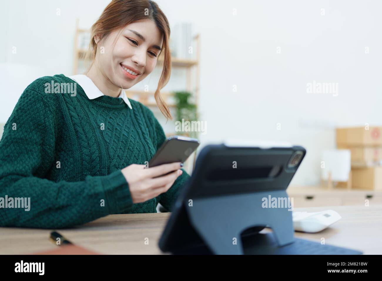 business owner or Asian male marketers are using smart phone and tablet ...