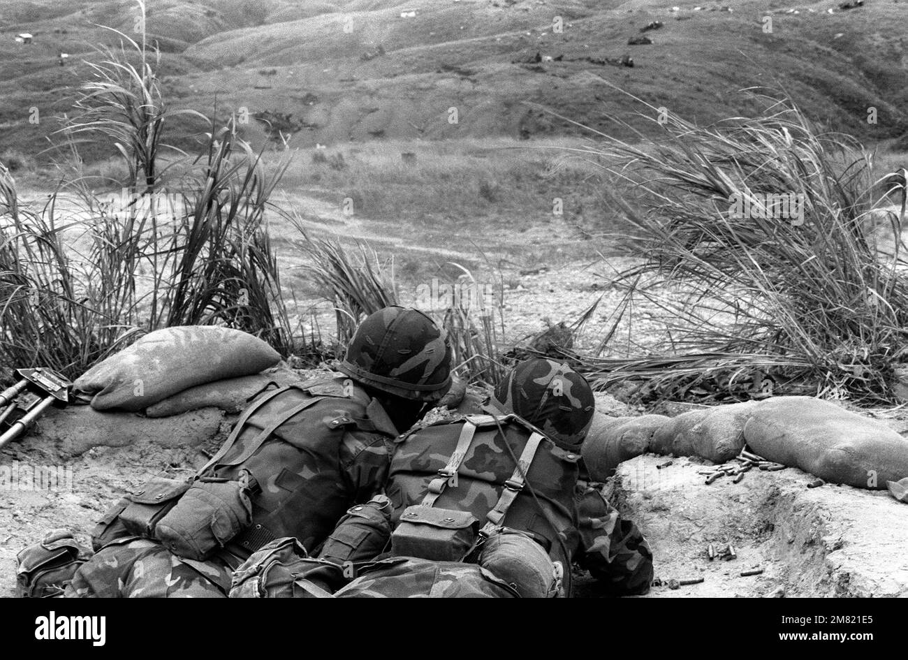 Two Marines look down range during a live fire exercise. Base: Marine ...