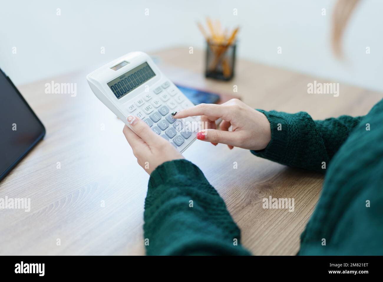 business owner or Asian female marketers are using calculator to ...