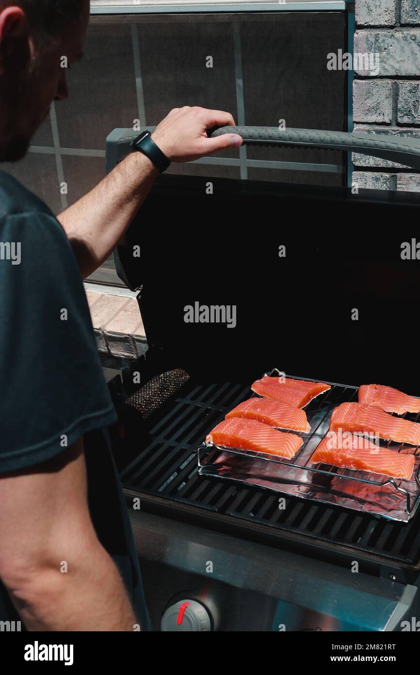 close up of man putting fresh salmon steaks on a grill Stock Photo - Alamy