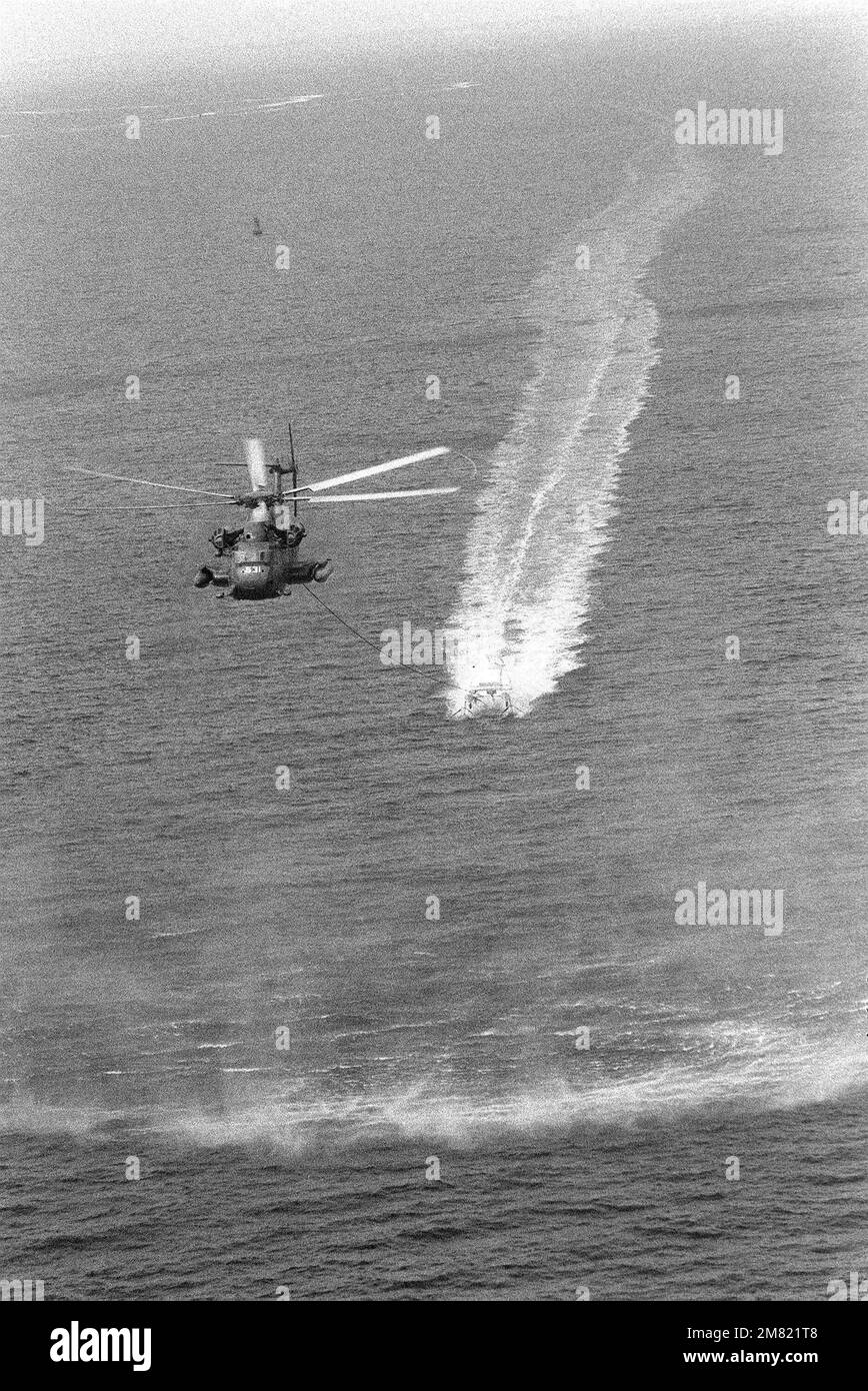An air-to-air front view of an RH-53D Sea Stallion towing a mine ...