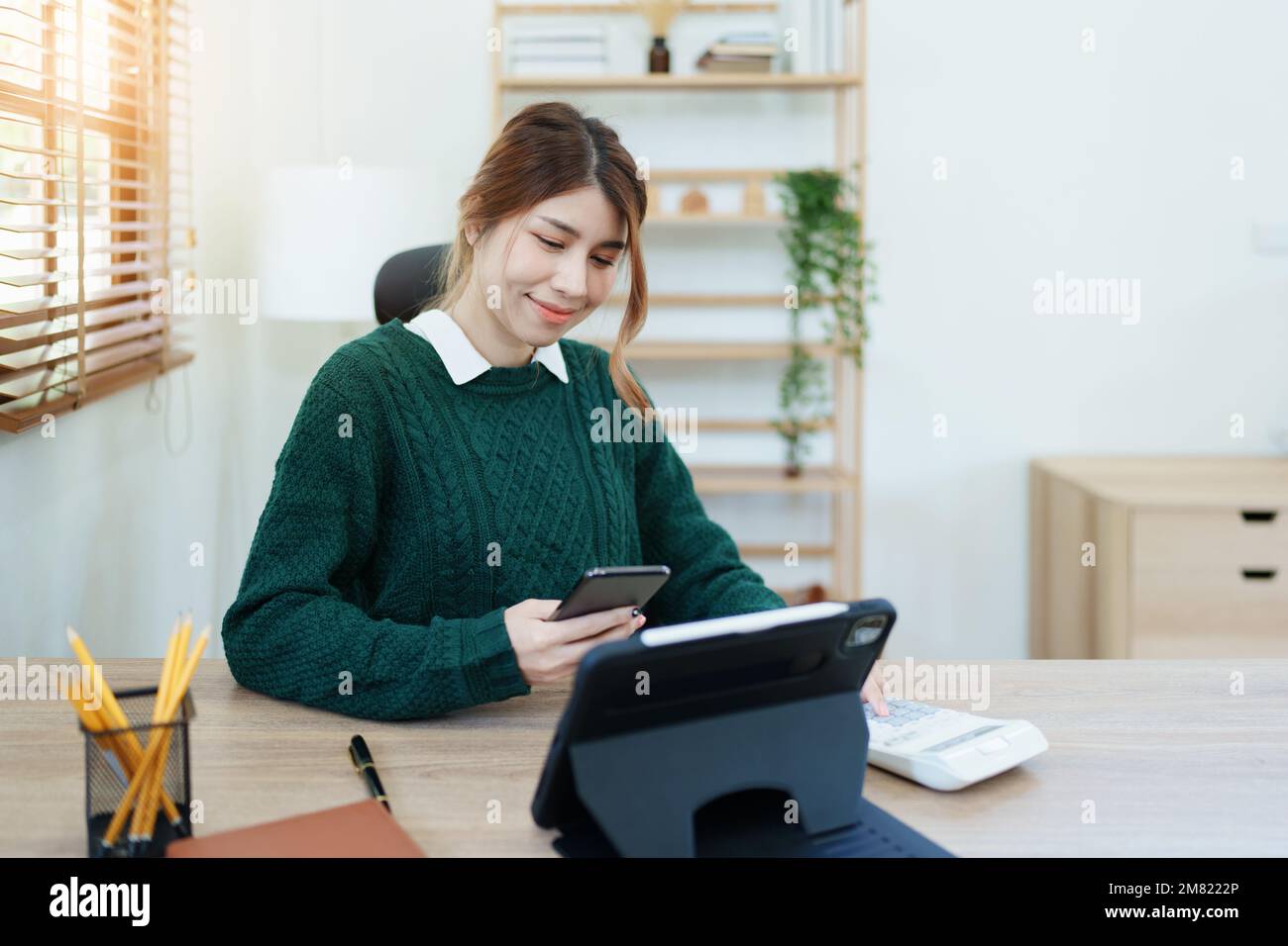 business owner or Asian male marketers are using smart phone and tablet ...