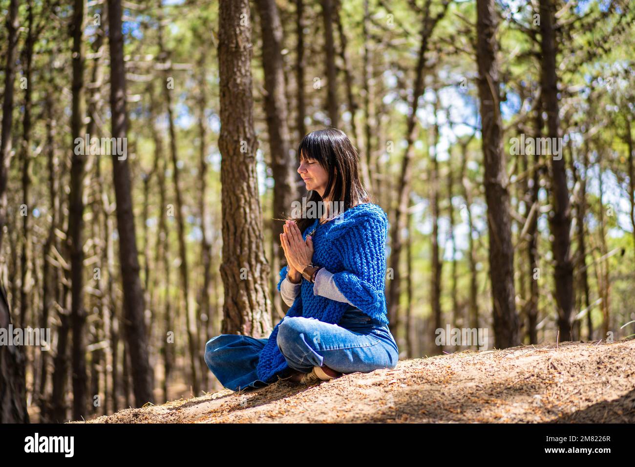 Side view of a woman clasping hands in the woods. Namaste pose Stock ...