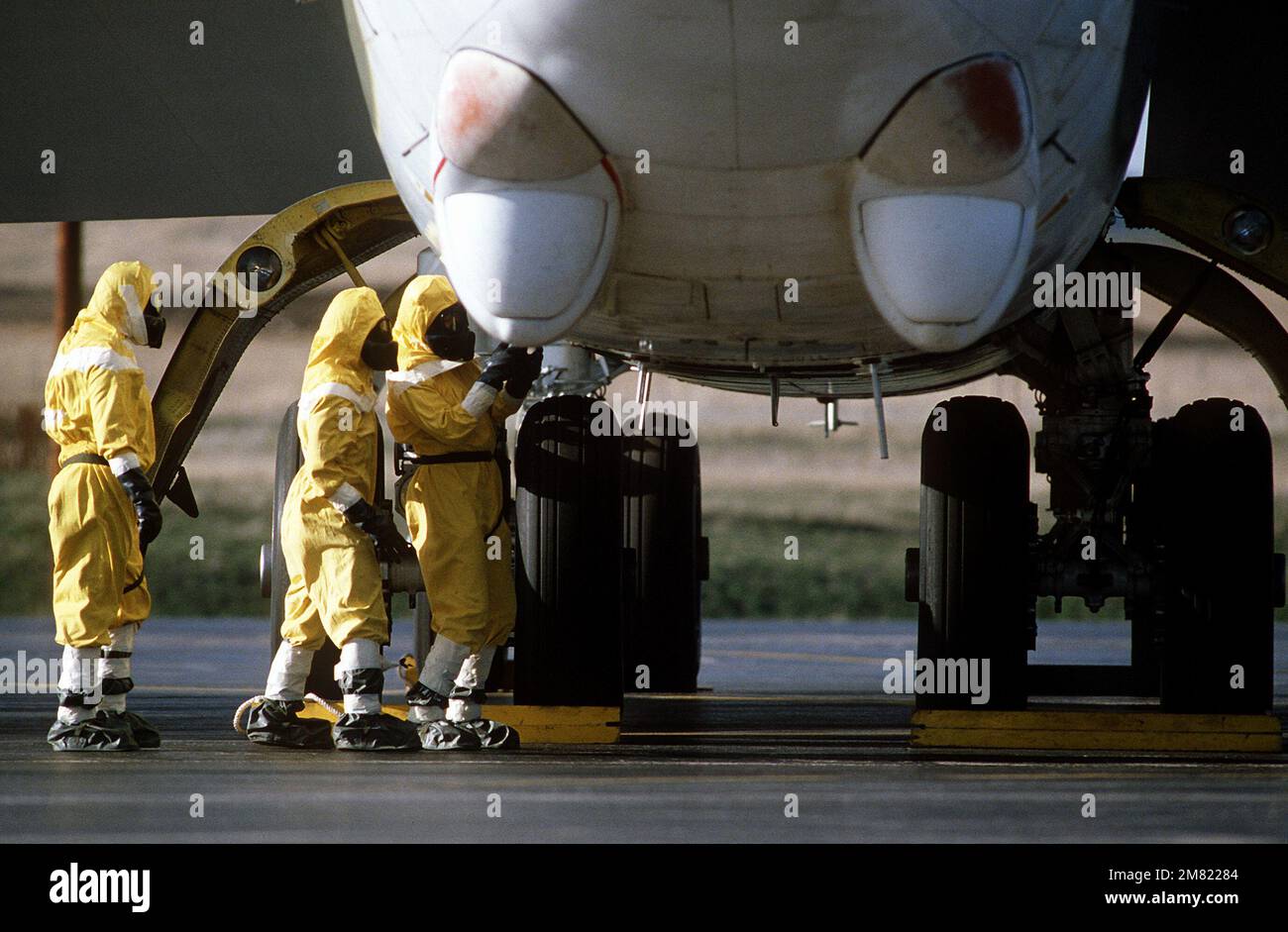Ground crewmen, wearing nuclear-biological-chemical (NBC) clothing ...