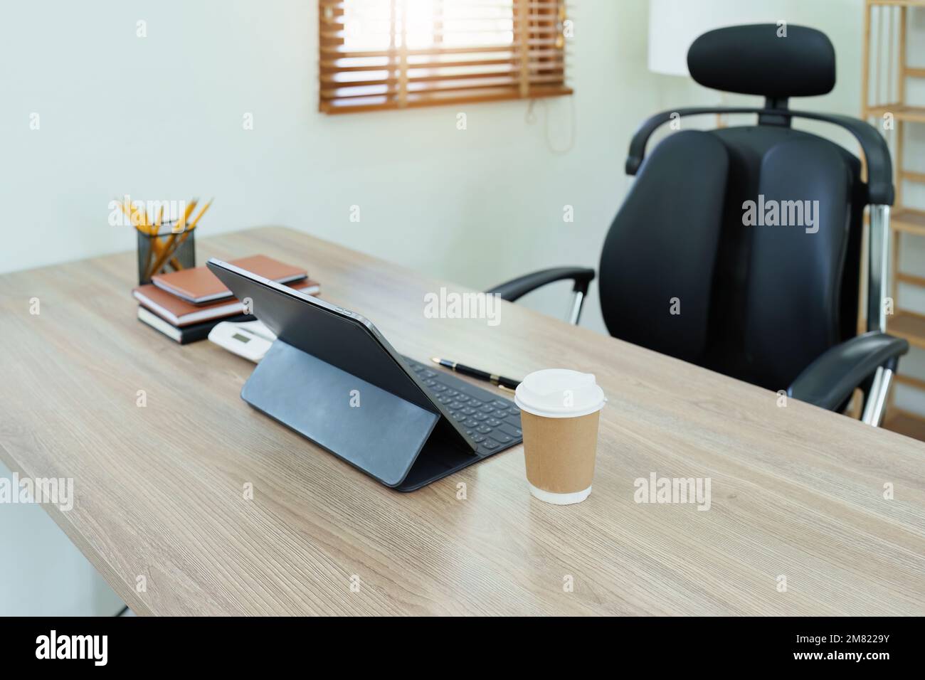 Tablet computer, notebook, calculator and coffee cup on the desk in the ...