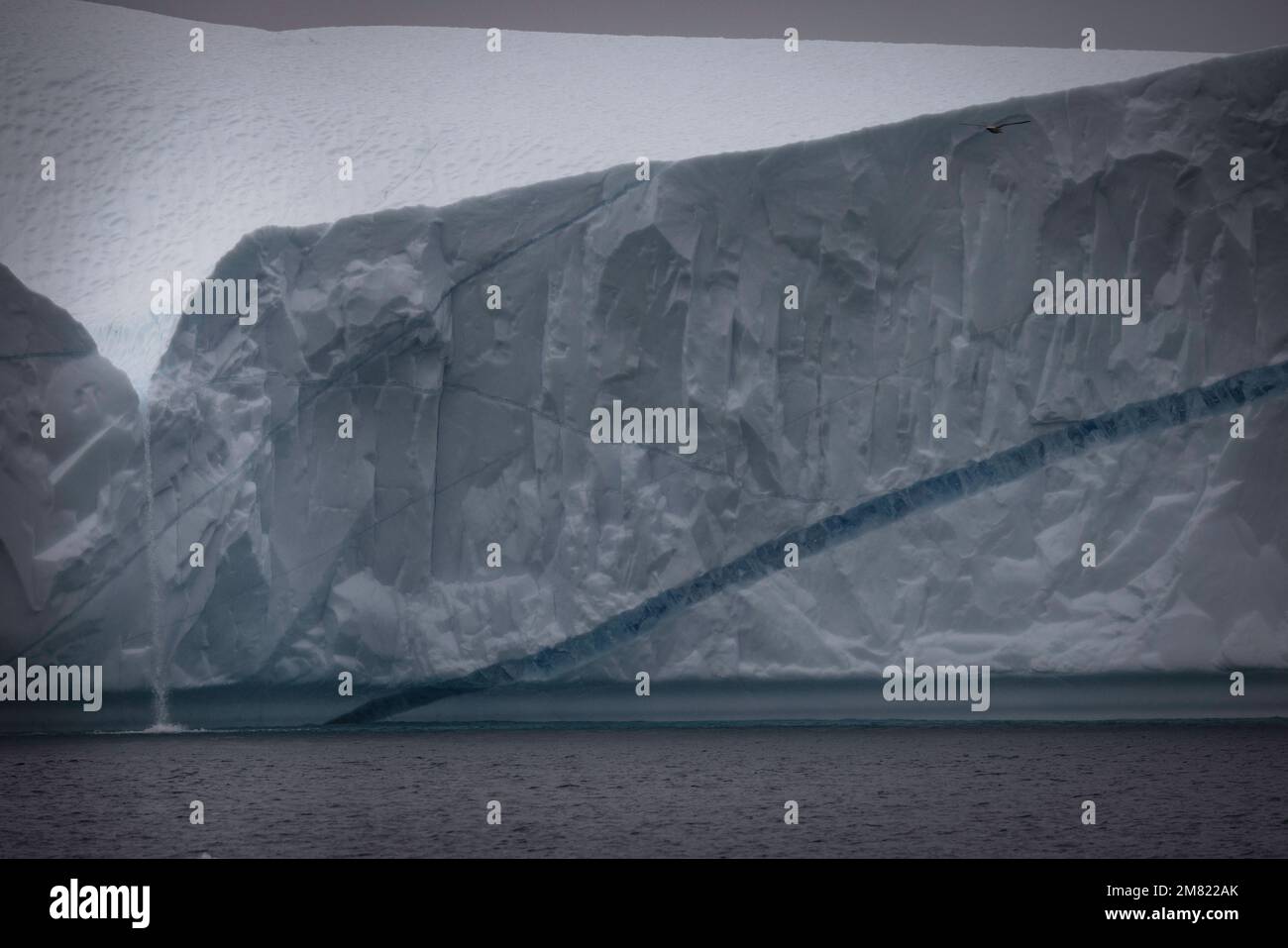 little waterfall over big iceberg wall Stock Photo - Alamy