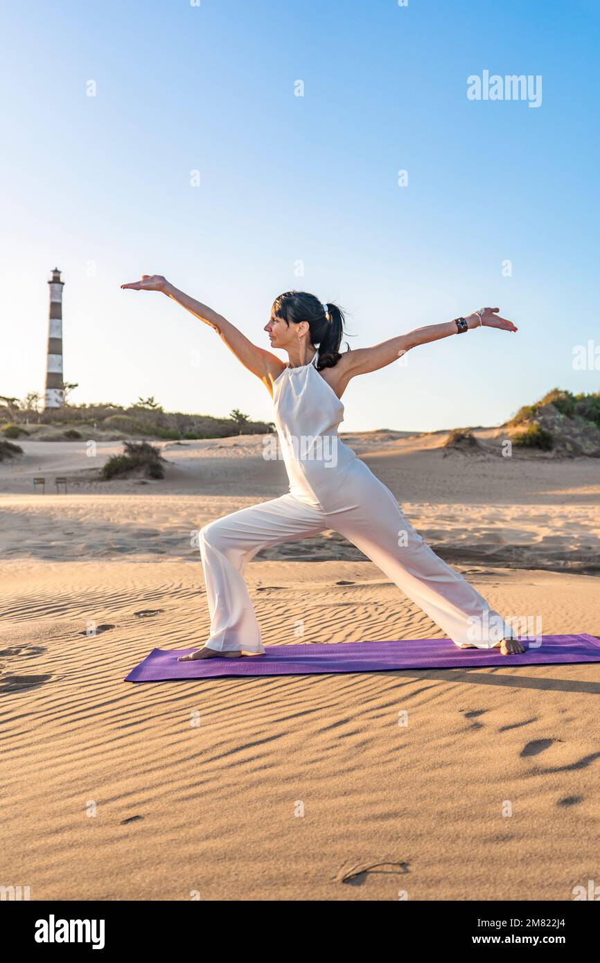Side view of calm female standing while practicing yoga Stock Photo - Alamy
