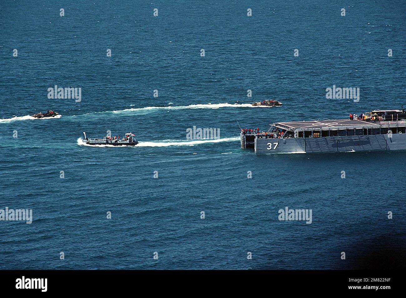 A utility landing craft and two Marine Corps LVTP-7 tracked landing ...