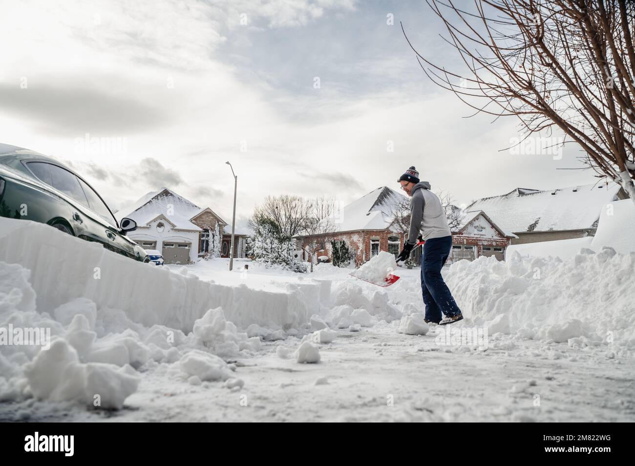 Man shoveling snow off of his driveway after a winter storm Stock Photo ...