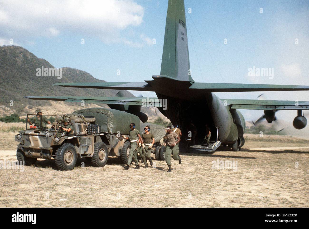 An M-561 gamma goat 1 1/2-ton truck is driven from the back of a C-130 ...