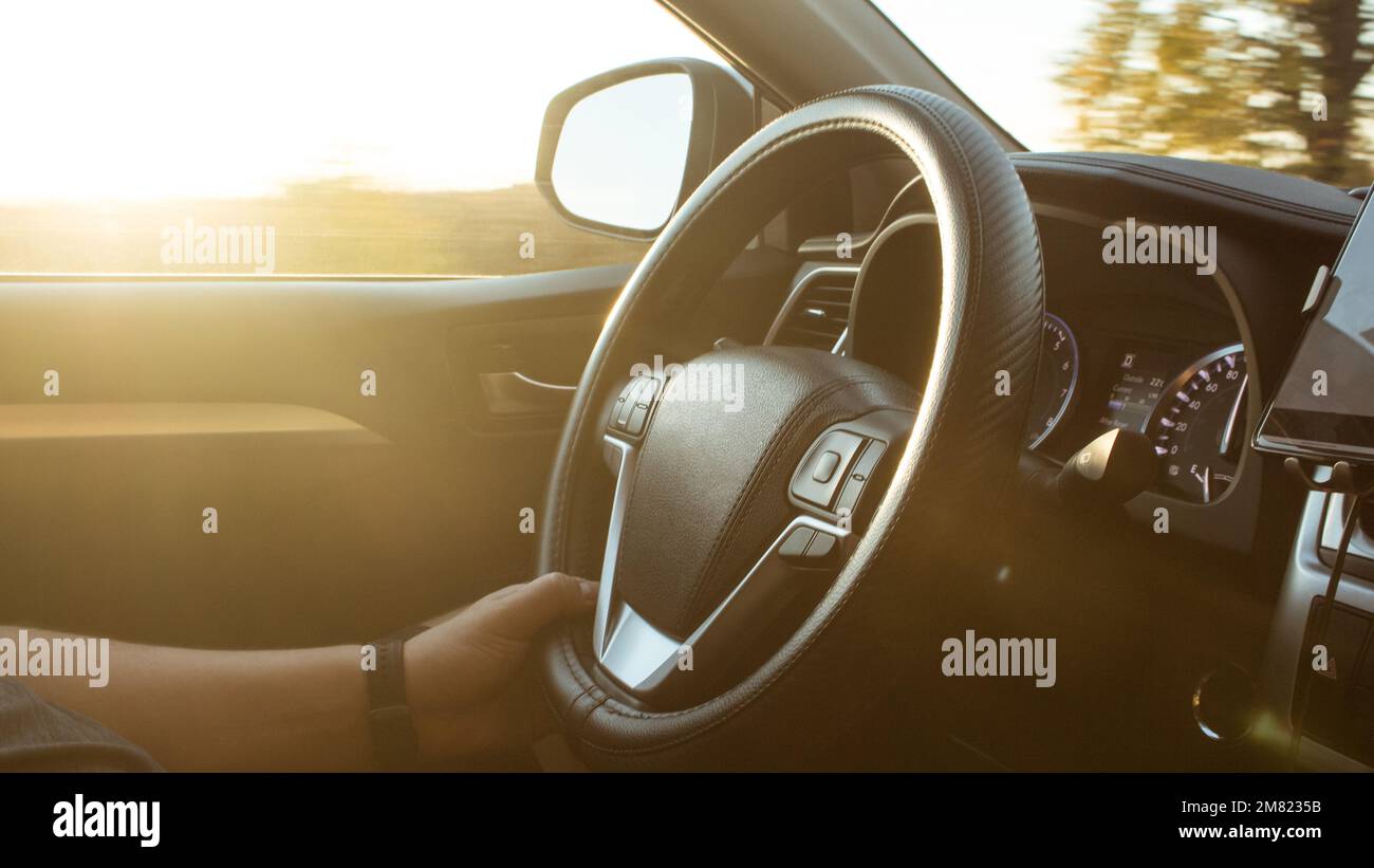 Man is driving vehicle with sun flare from the outside in the sunny day ...
