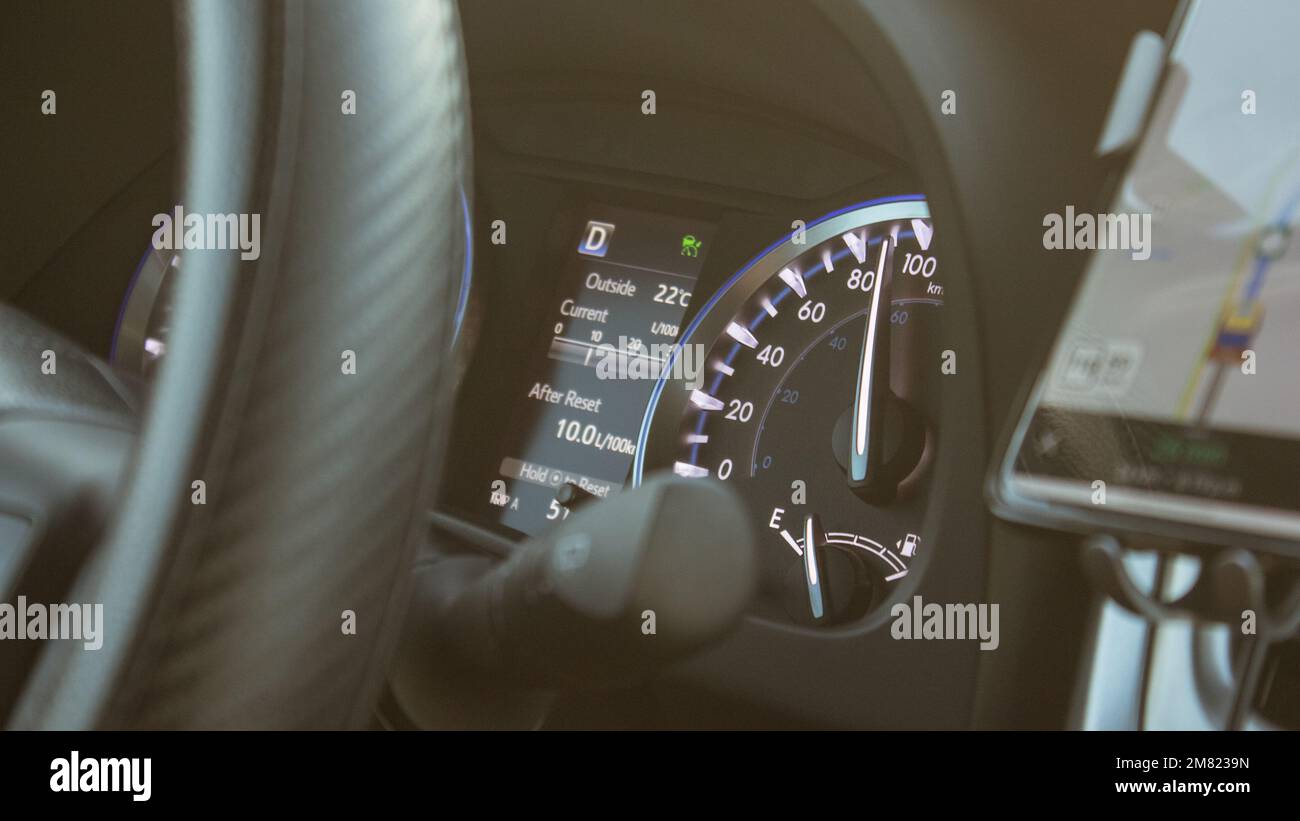 Illuminated speedometer dashboard and steering wheel of a modern car in ...