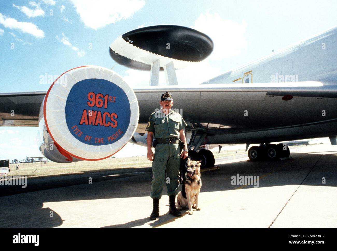 A RAAF security policeman and his German shepherd stand guard in front ...