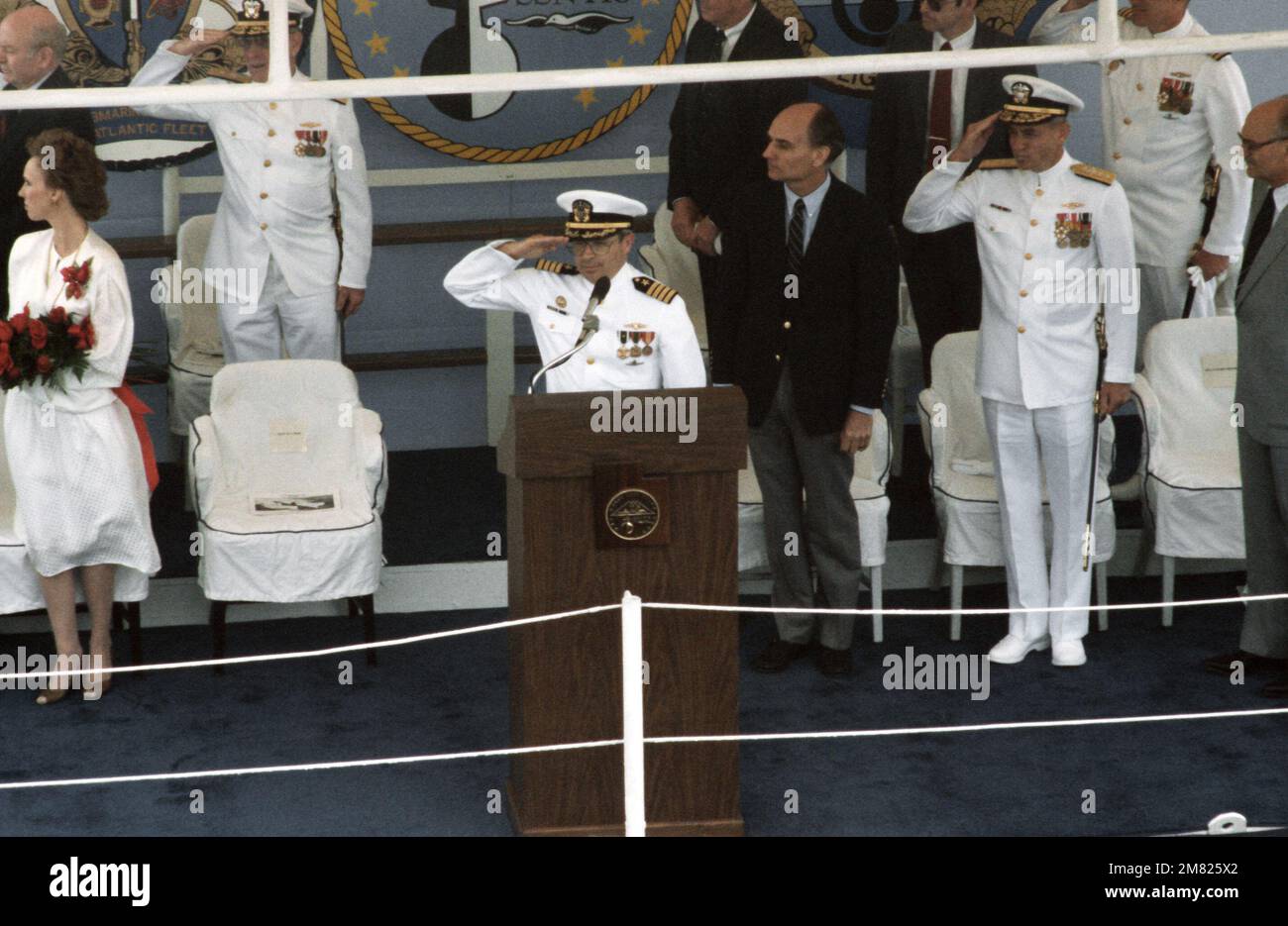 Distinguished guests stand and officers salute as the nuclear-powered ...