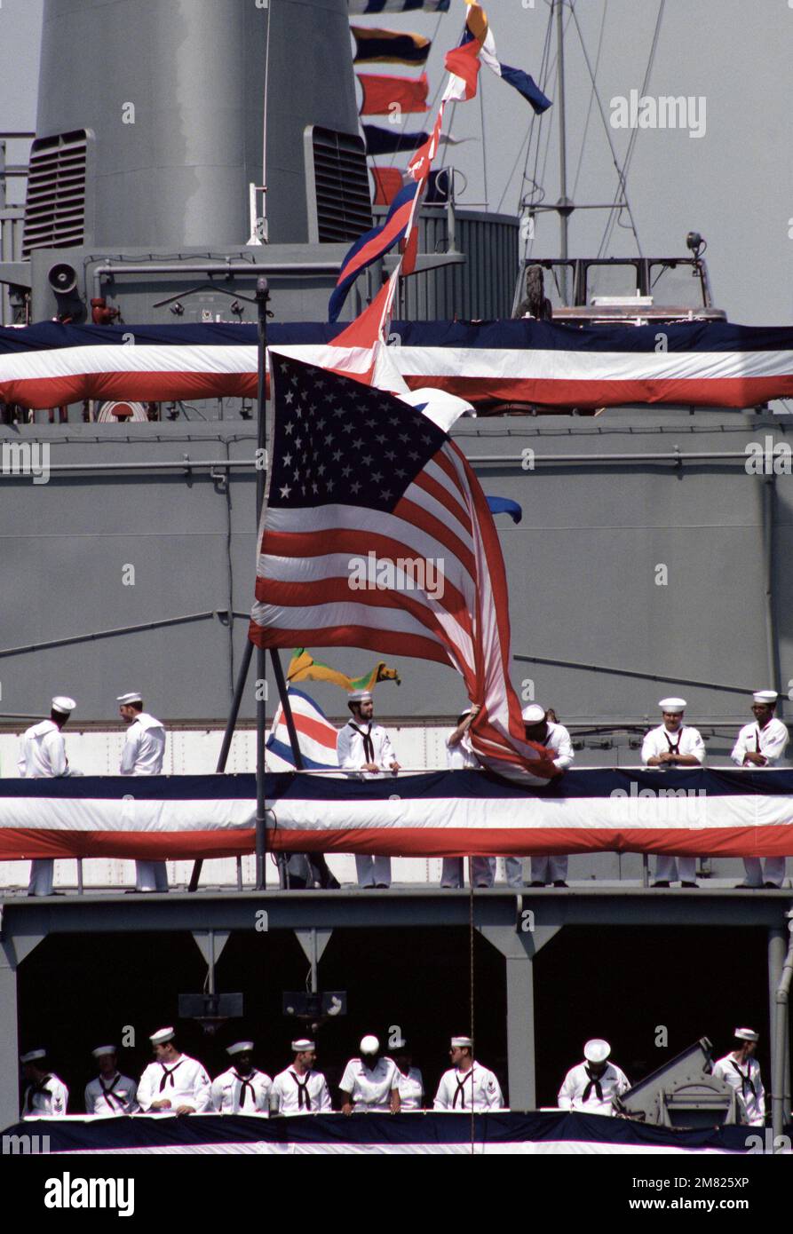 Crewmen line the stern rails of the submarine tender USS EMORY S. LAND ...
