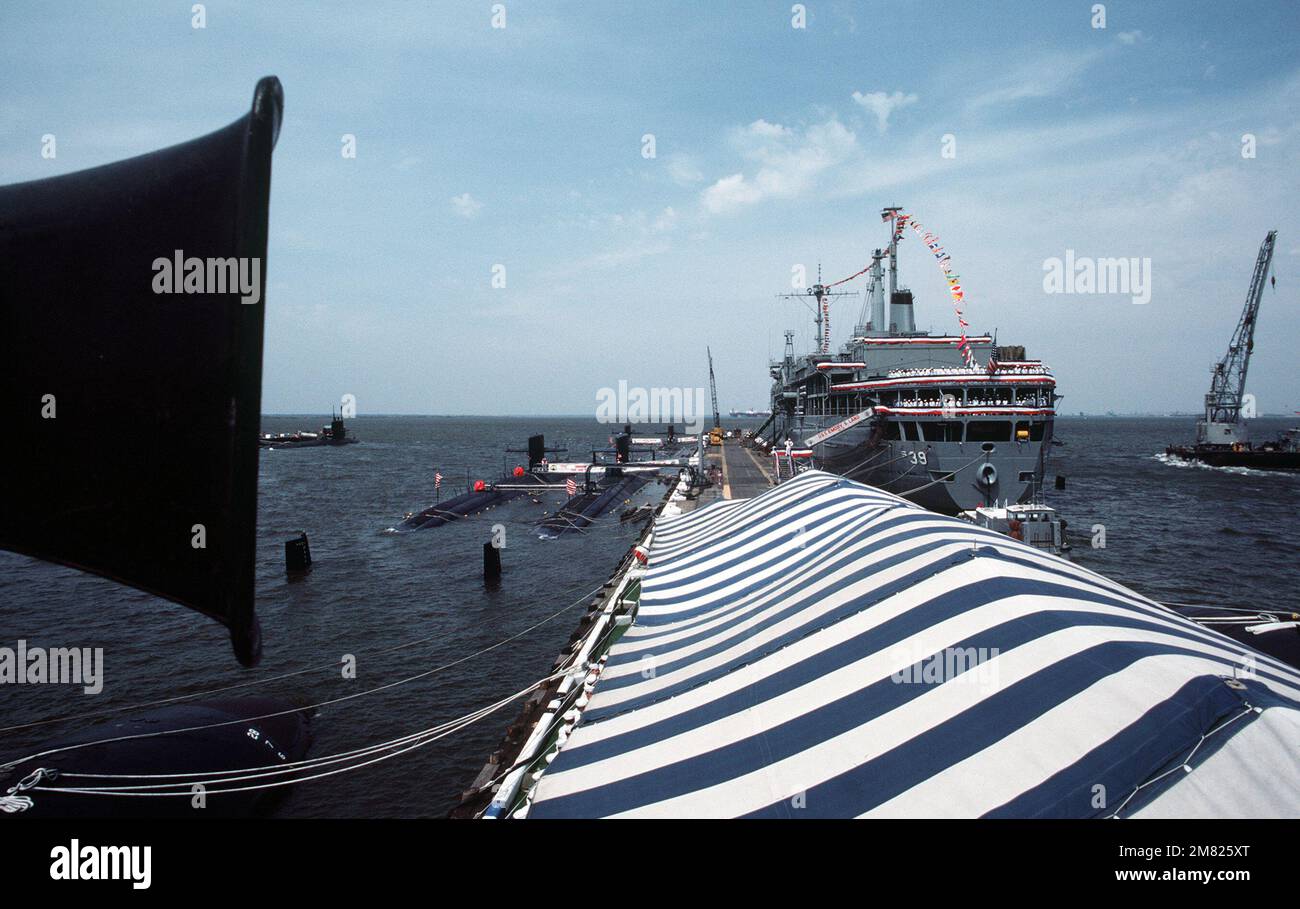A view of the submarine tender USS EMORY S. LAND (AS 39) and several ...