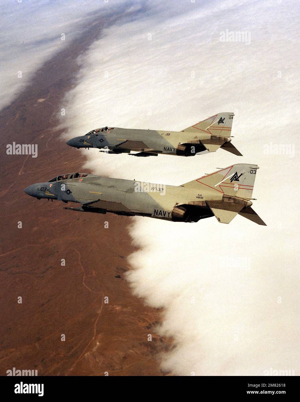 An air-to-air left side view of two Fighter Squadron 301 (VF-301) F-4 ...