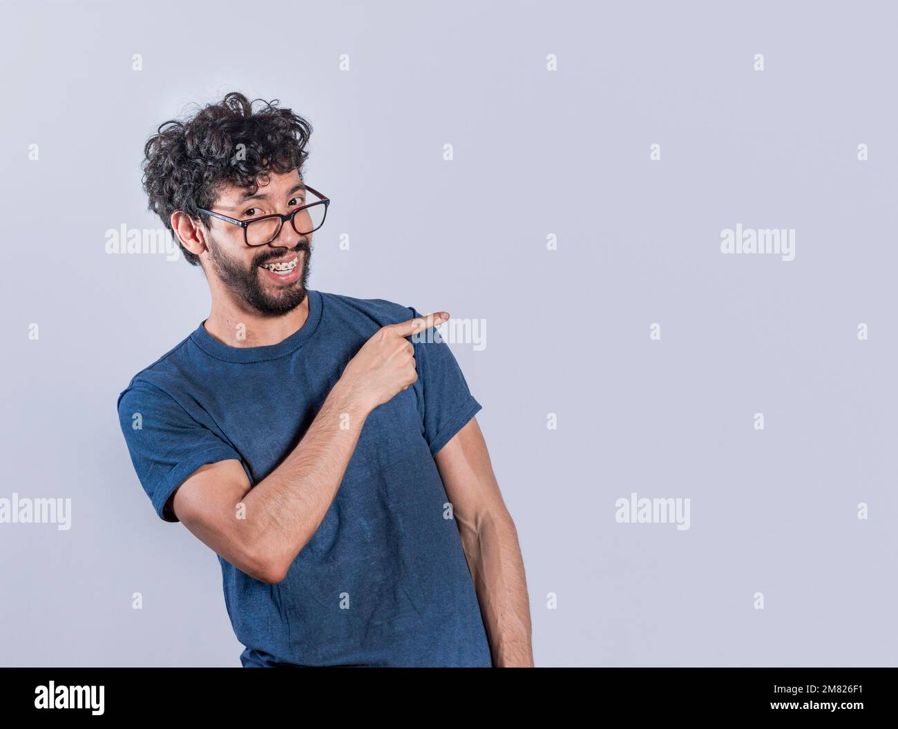 Friendly handsome man pointing two fingers to the side, Smiling ...