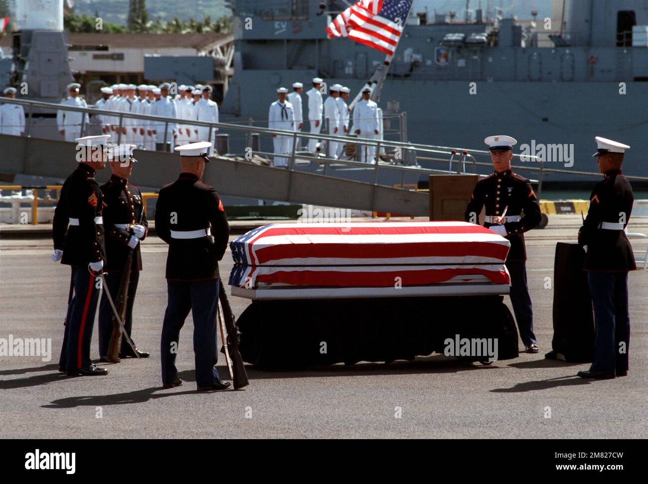 A Marine Corps honor guard stands around the flag-draped casket of the ...