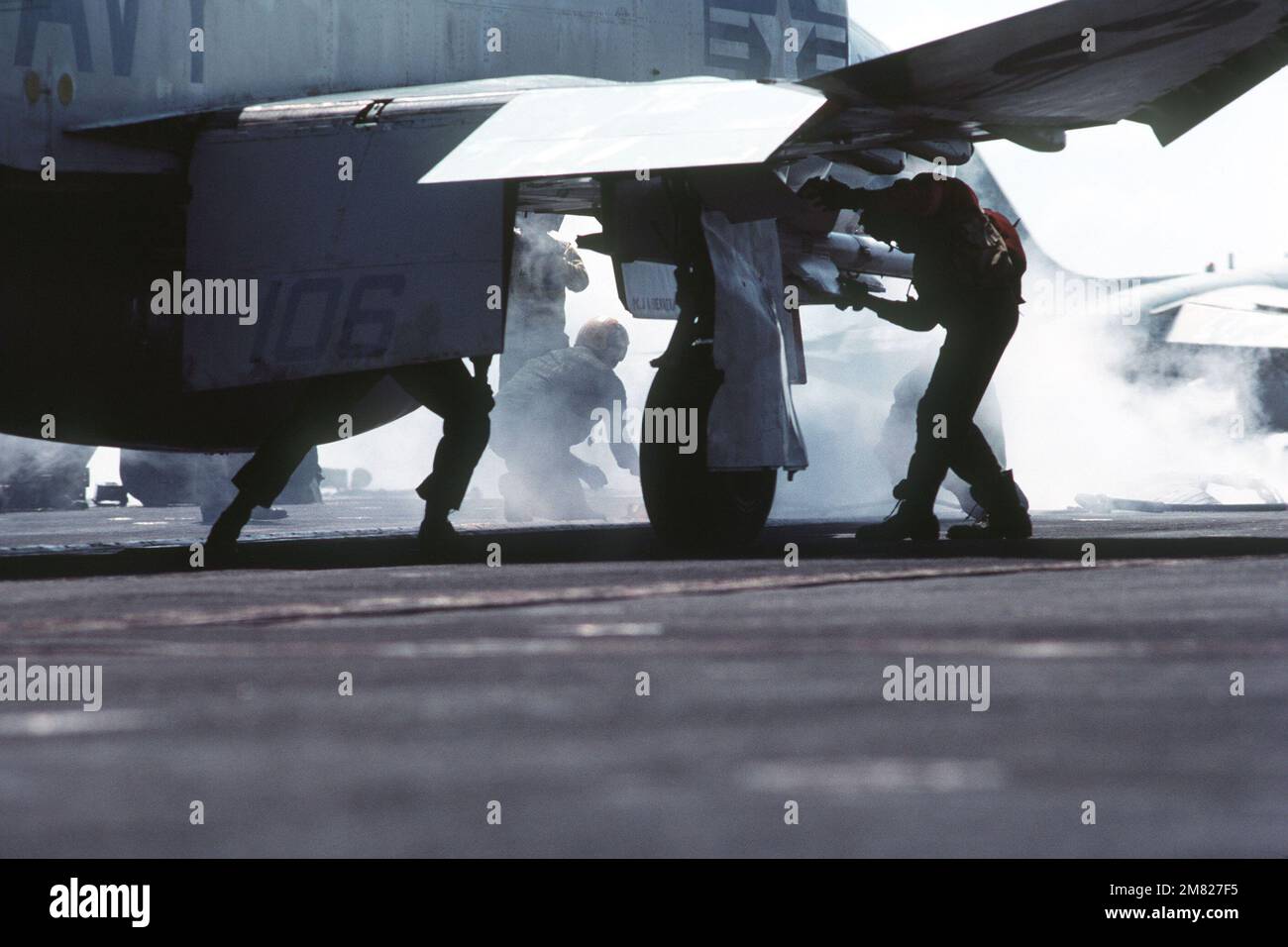 Crewman aboard the aircraft carrier USS MIDWAY (CV 41) load an AIM-9 ...