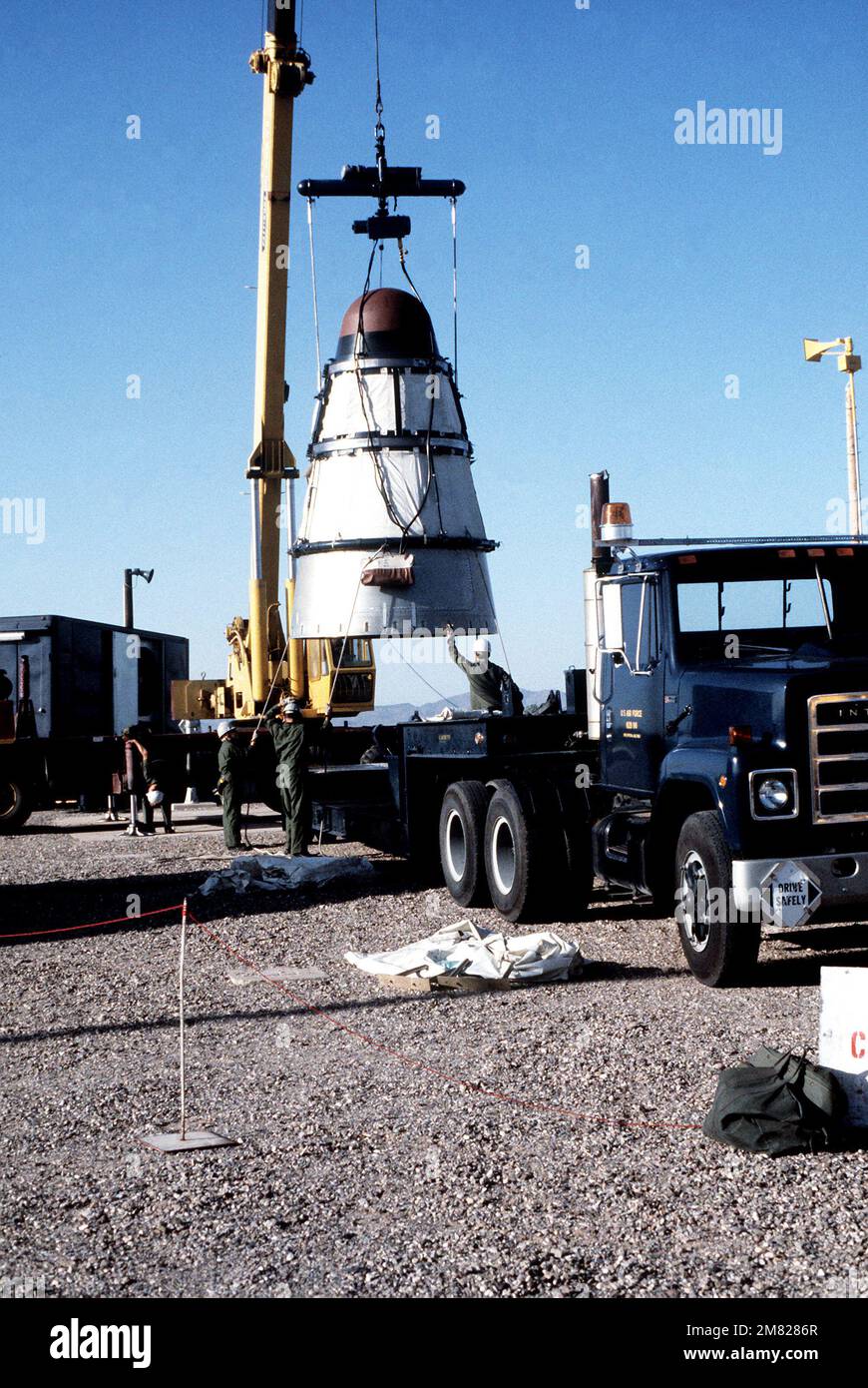 A Titan II reentry vehicle is lowered by crane onto a radio frequency ...