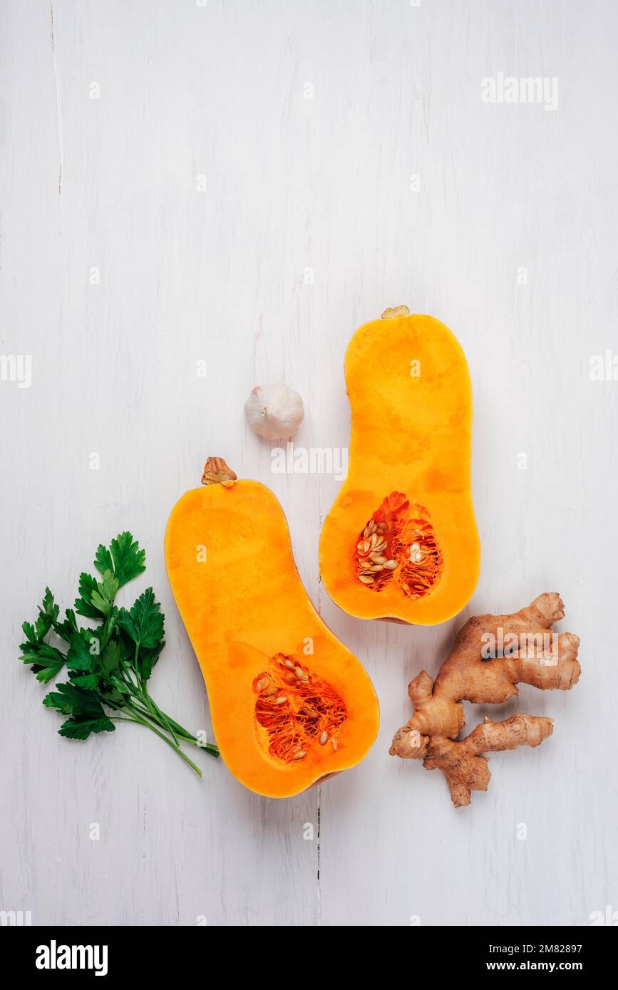 Raw butternut squash with ginger, garlic and parsley on white wooden ...