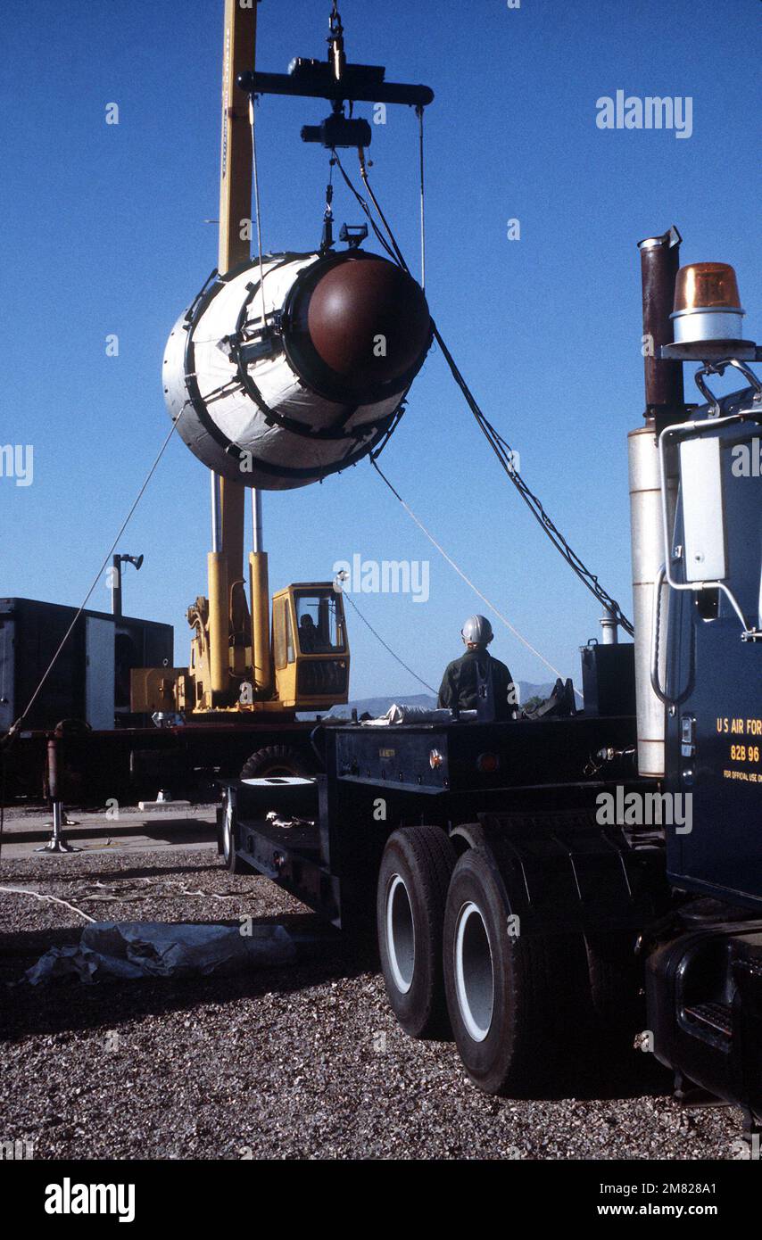 A Titan II reentry vehicle is positioned horizontally for lowering onto ...
