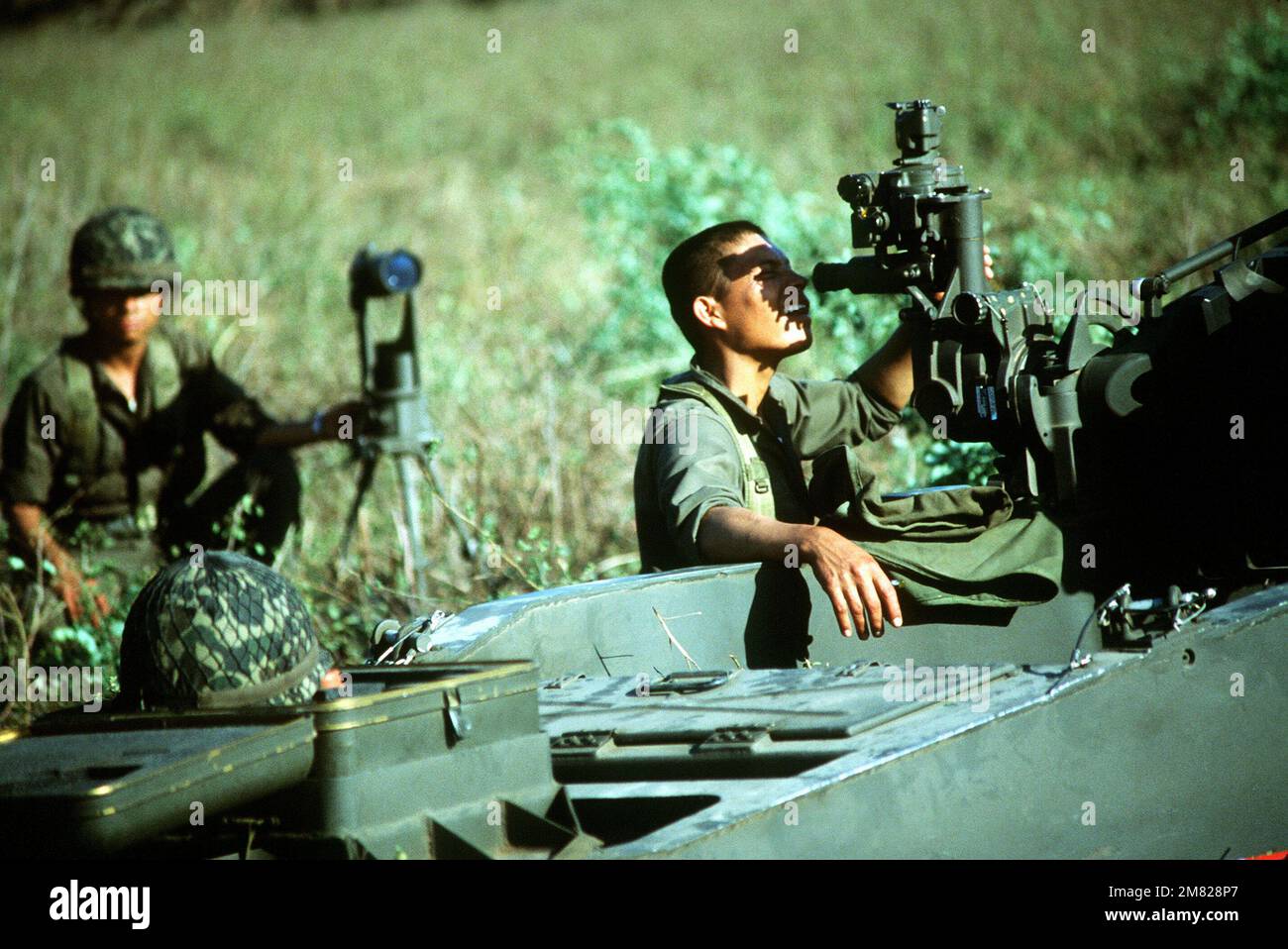 A Honduran soldier adjusts the sight on an M102 105 mm howitzer during ...