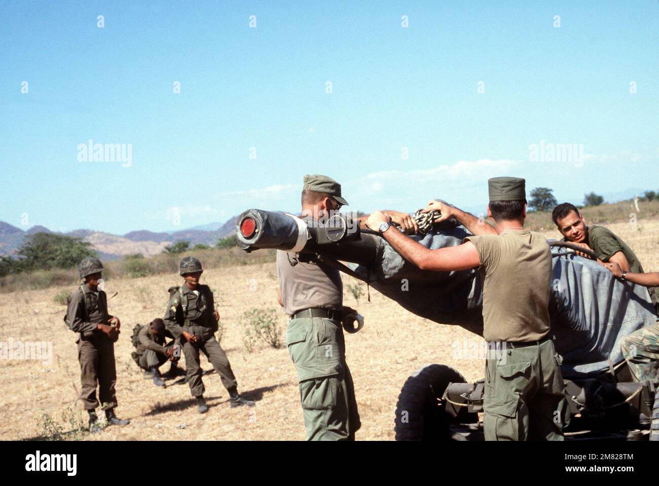 Soldiers prepare an M102 105 mm howitzer to be airlifted by a CH-47 ...