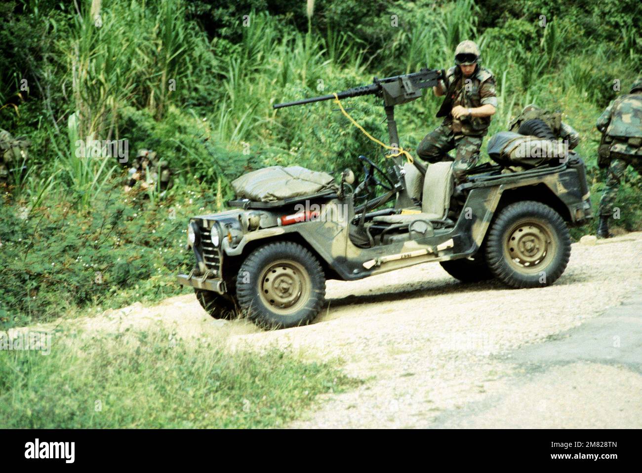 A soldier mans an M2 .50-caliber machine gun mounted in a jeep during ...