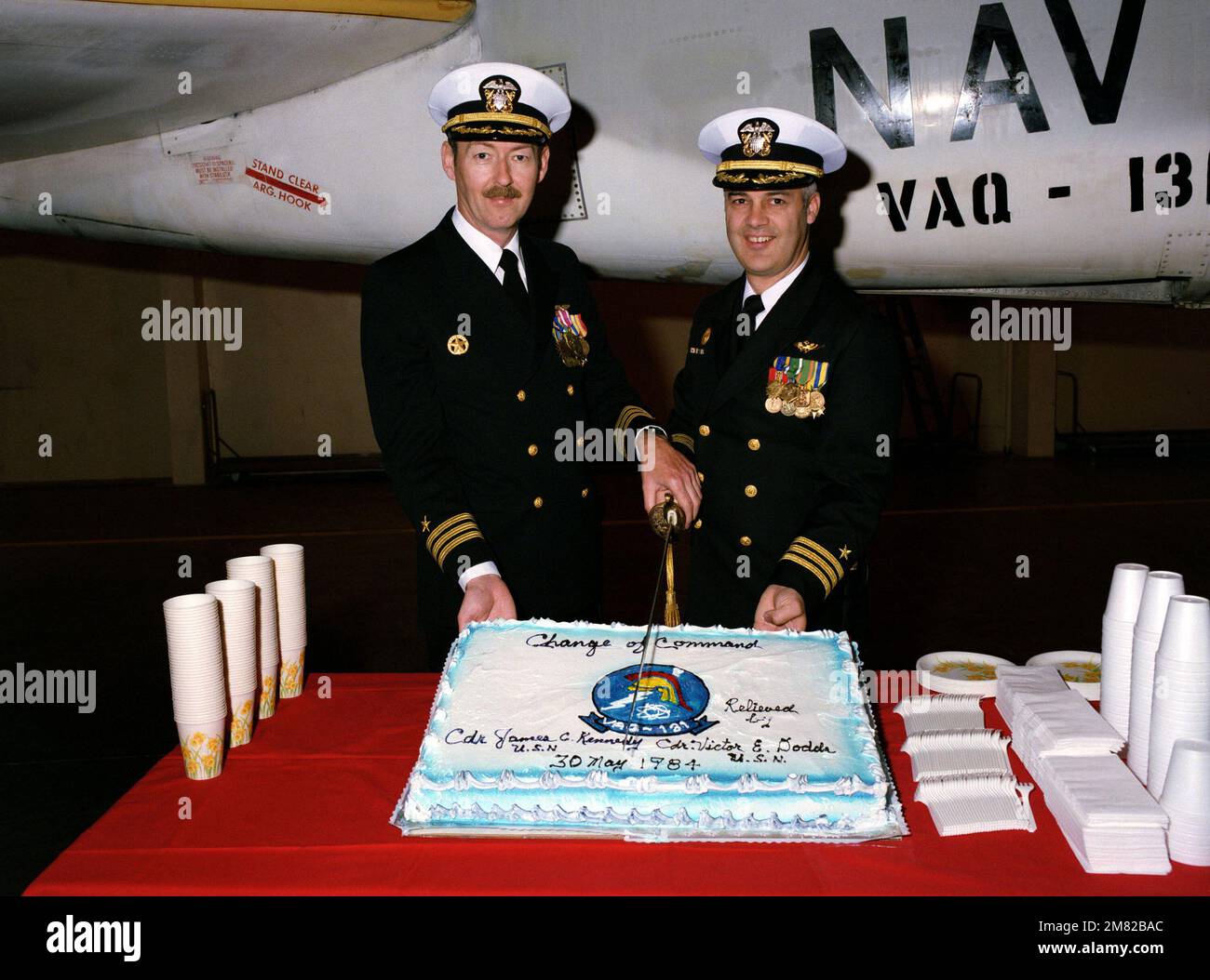 Commander (CDR) James C. Kennedy, left, and CDR Victor E. Dobbs cut the ...
