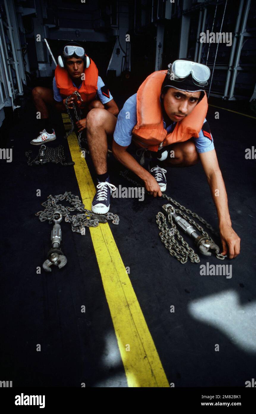 Flight deck crewmen lay out tie-down chains aboard the Venezuelan ...