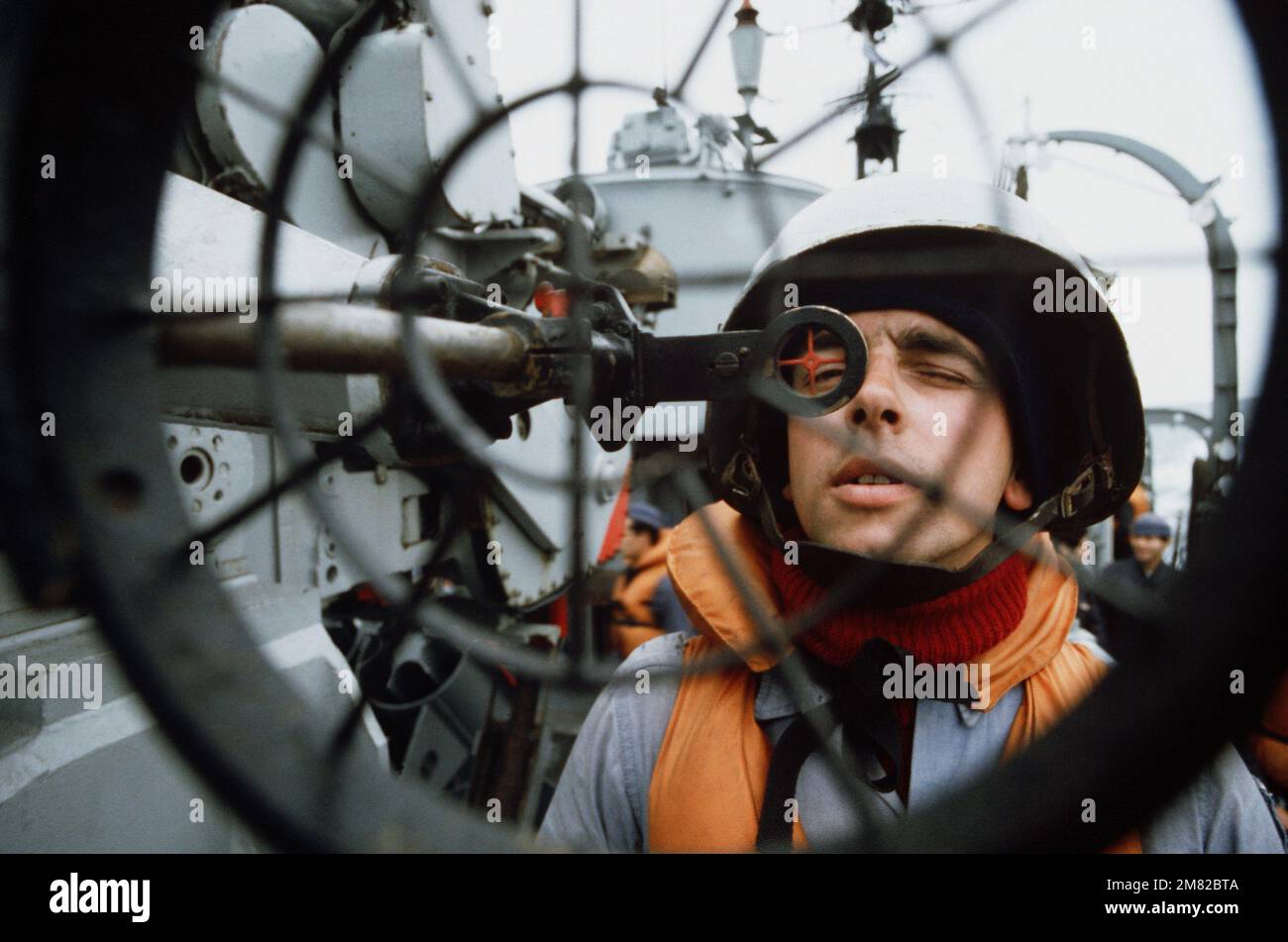 A gunner examines the sights on his 3-inch gun aboard the Uruguayan ...