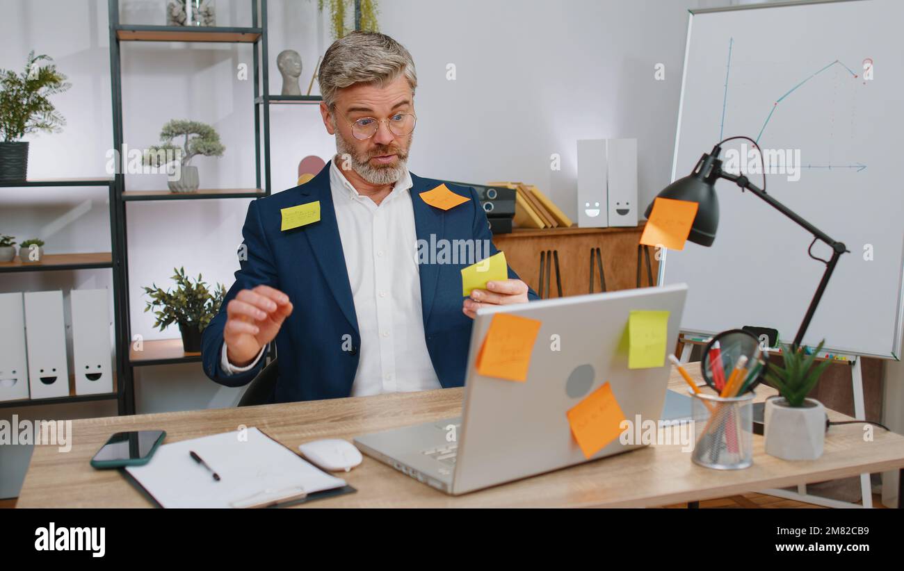 Tired exhausted mature businessman working on laptop at office with ...