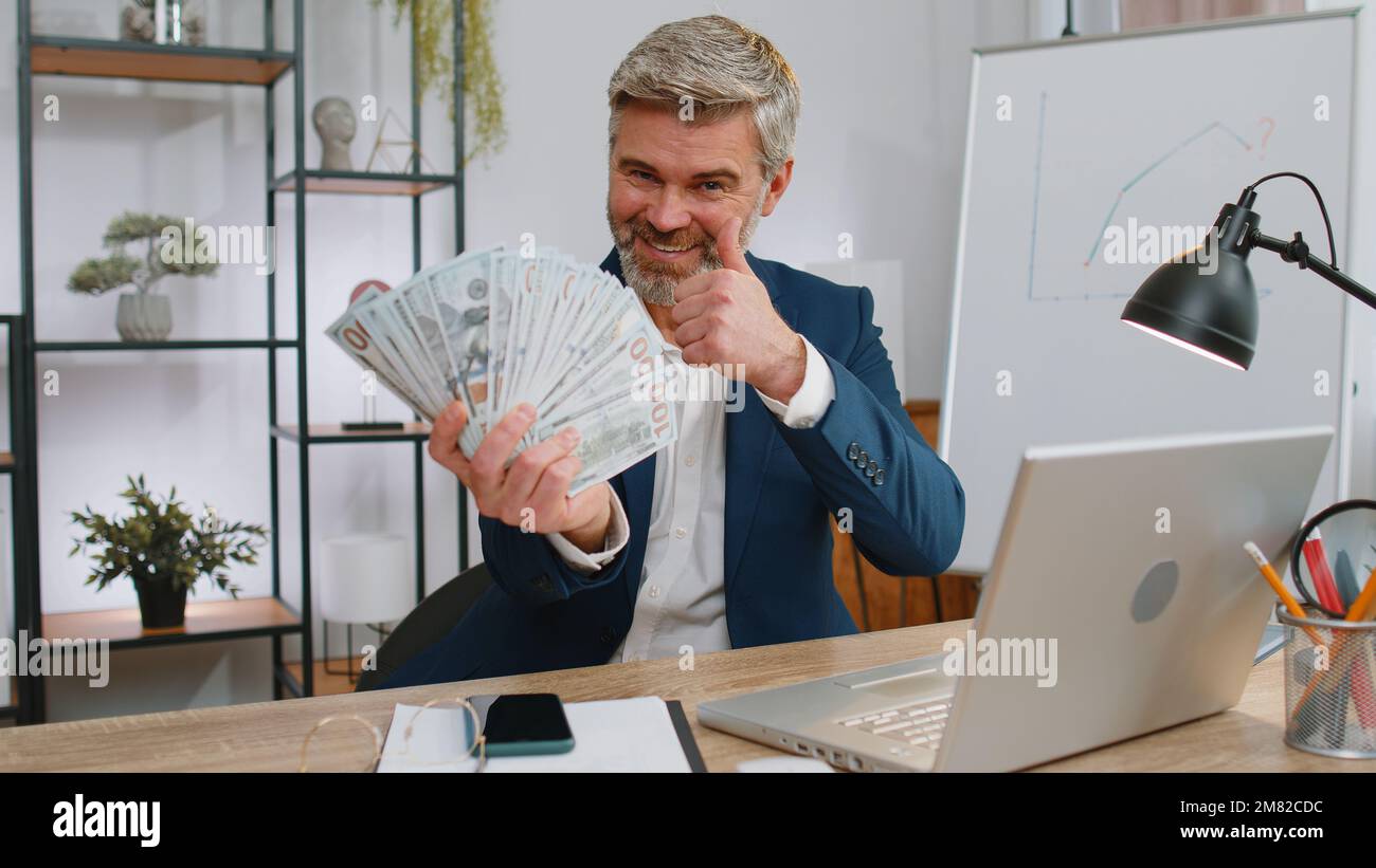 Rich pleased boss middle aged businessman waving money dollar cash ...