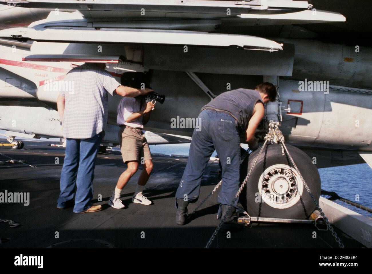 A member of the Naval Audiovisual Center motion picture shoot films an ...