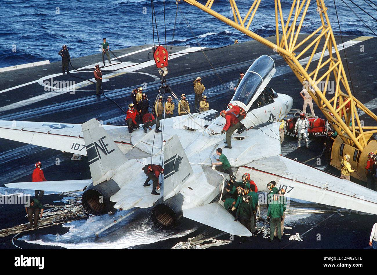 Crew members use an NP-50 crane to remove a damaged F-14A Tomcat ...
