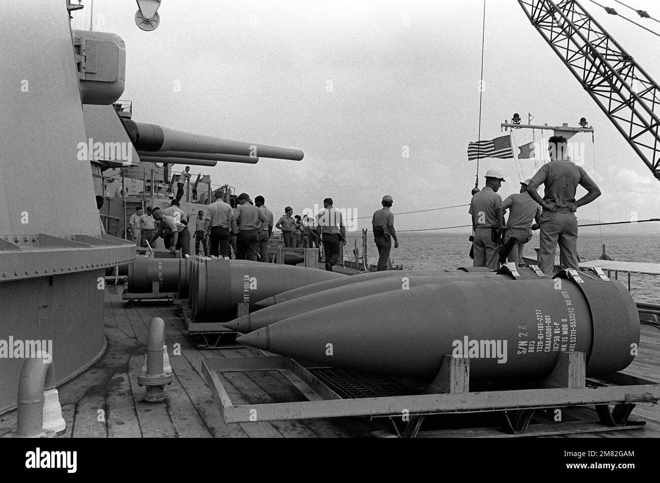 Sixteen-inch projectiles are loaded from a barge to the battleship USS ...