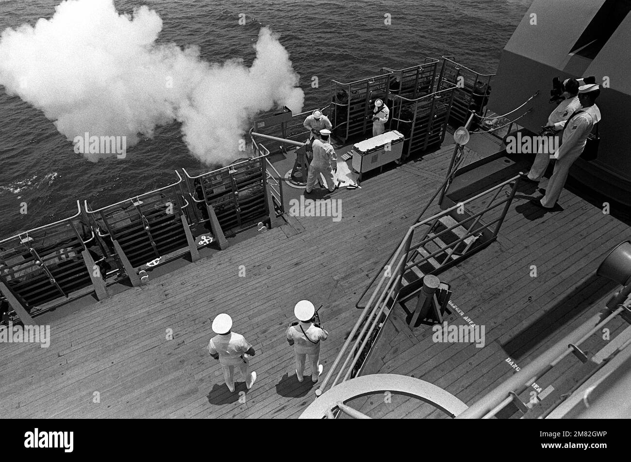 The starboard side saluting battery is fired aboard the battleship USS ...