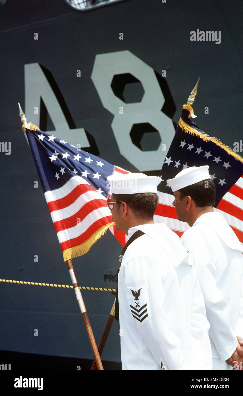 Two crewmen stand at ease near the bow of the Aegis guided missile ...
