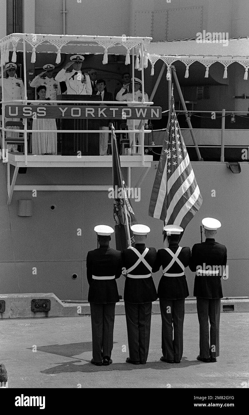Distinguished guests on the speakers platform salute a Marine Corps ...