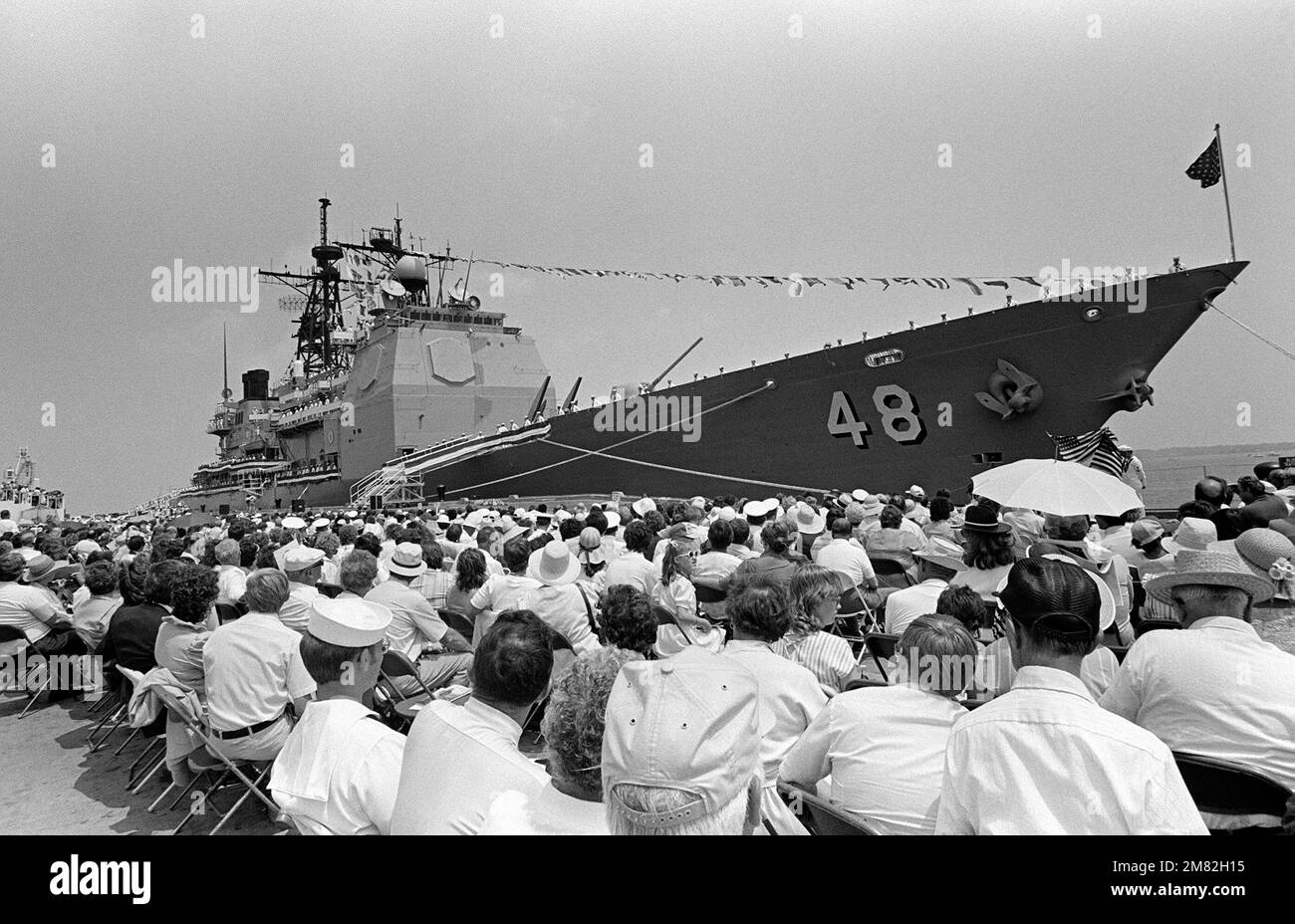 Guests look on as crew members of the Aegis guided missile cruiser USS ...