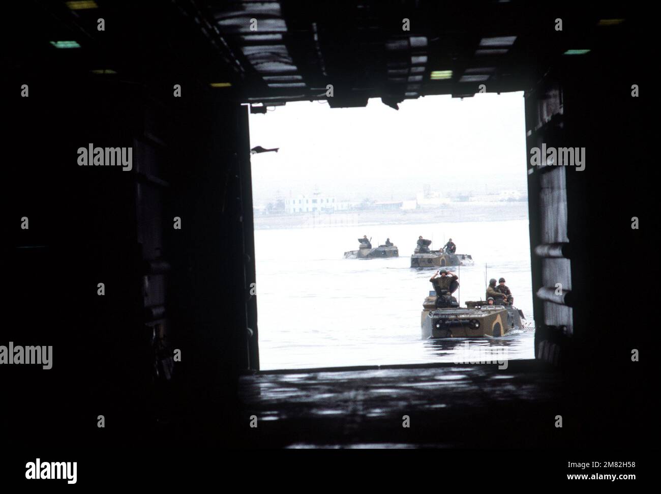 Three AAVP-7 amphibious assault vehicles approach the open stern gate ...