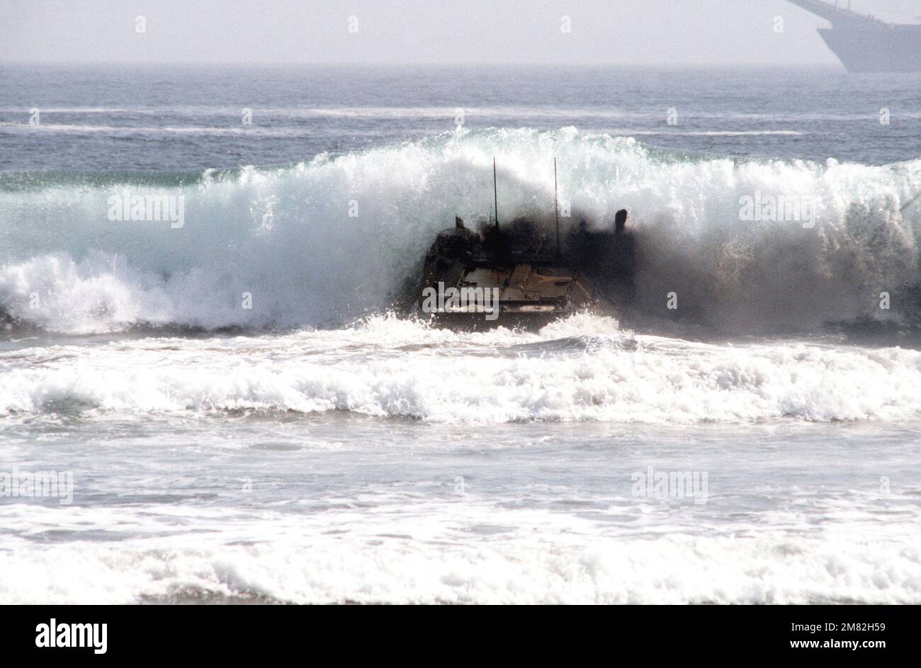 A wave breaks over the front of an AAVP-7 amphibious assault vehicle as ...