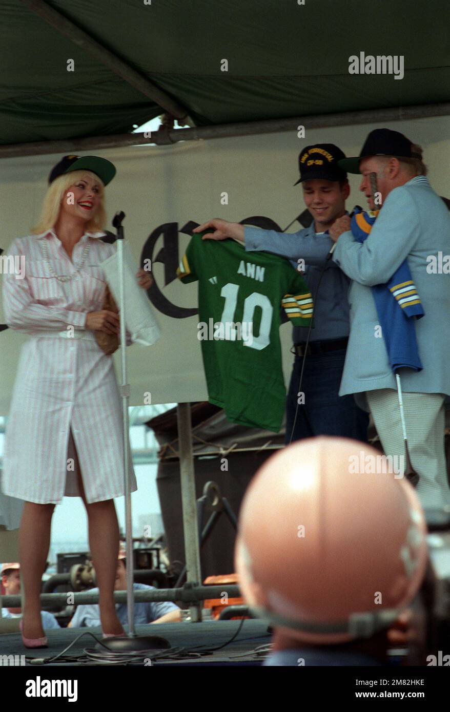 A sailor presents a Forrestal jersey to actress Ann Jillian during a 30 ...