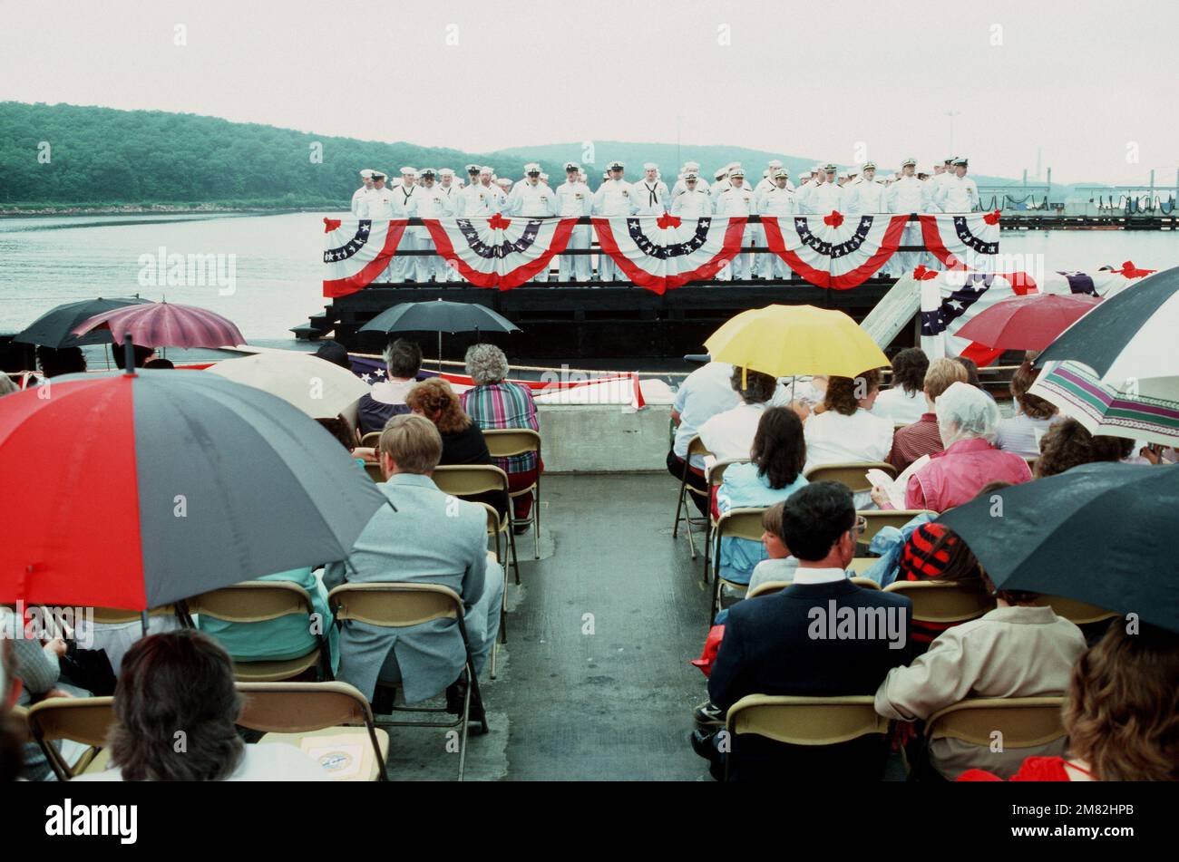 Guests look on as crewman stand in formation aboard the nuclear-powered ...